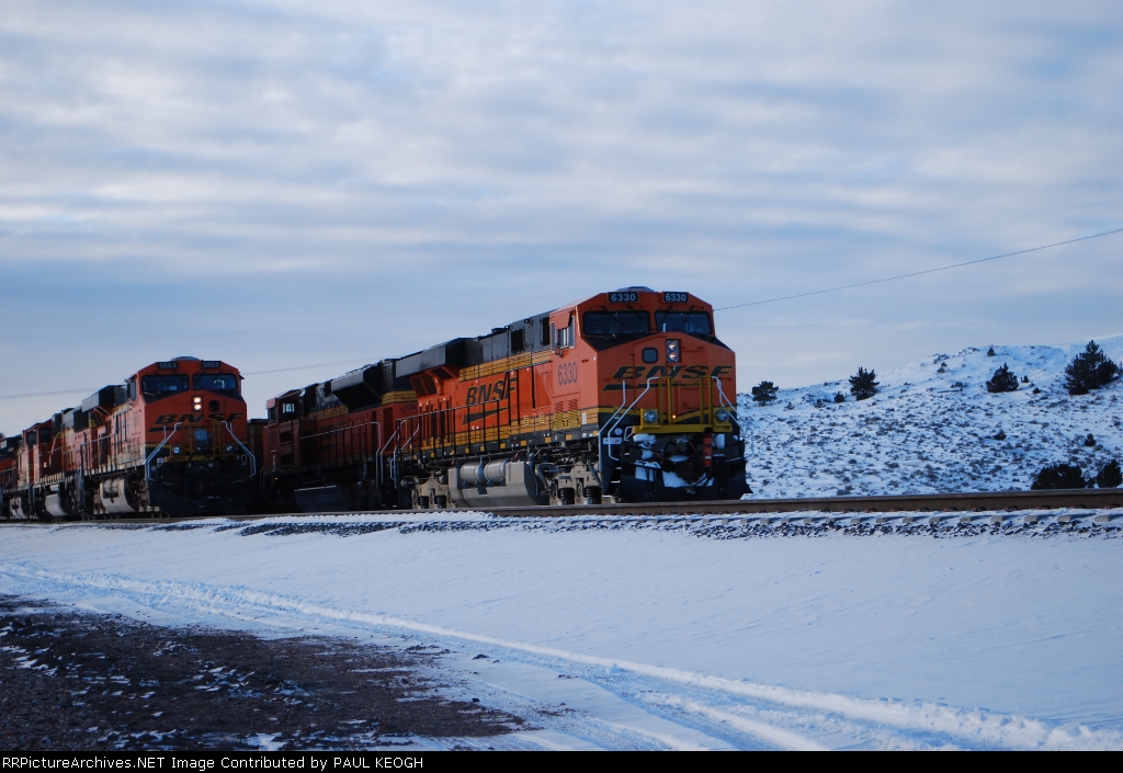 BNSF 6330 pushes a mty coal train south as she passes BNSF 5863 helper unit on this cold ...